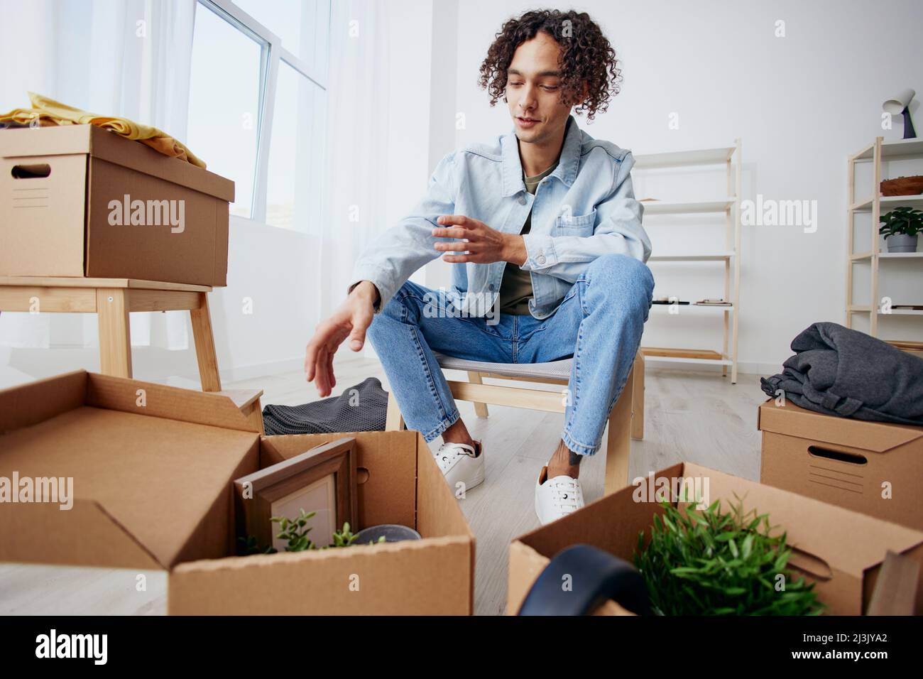 portrait of a man unpacking things from boxes in the room Lifestyle ...