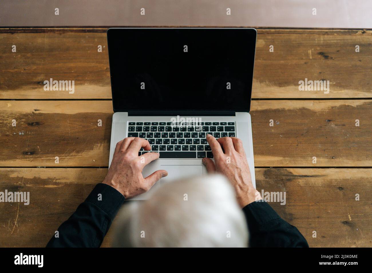 Close-up top view of unrecognizable gray-haired senior male using ...