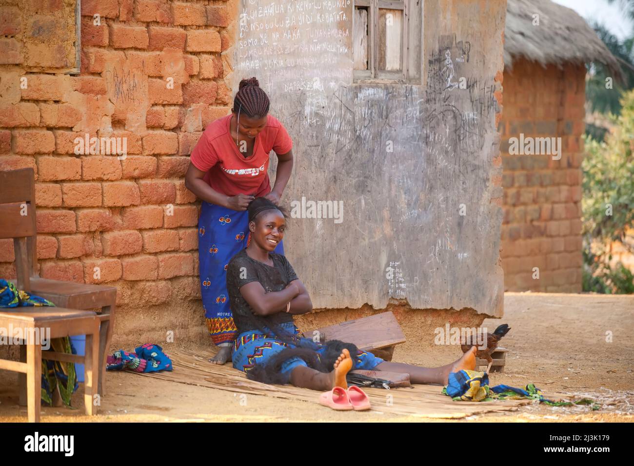 Women braiding their hair in the small Congolese village of Bulu.; Bulu ...