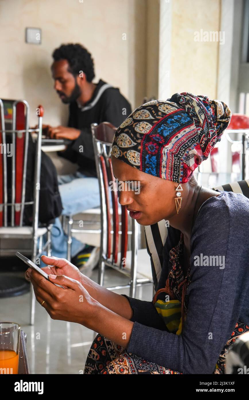 Ethiopian woman sits in a cafe using a smart phone; Ethiopia Stock ...