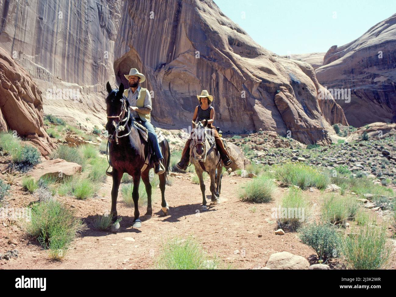 Horseback riders navigate the narrow, dangerous Navajo Trail, or ...