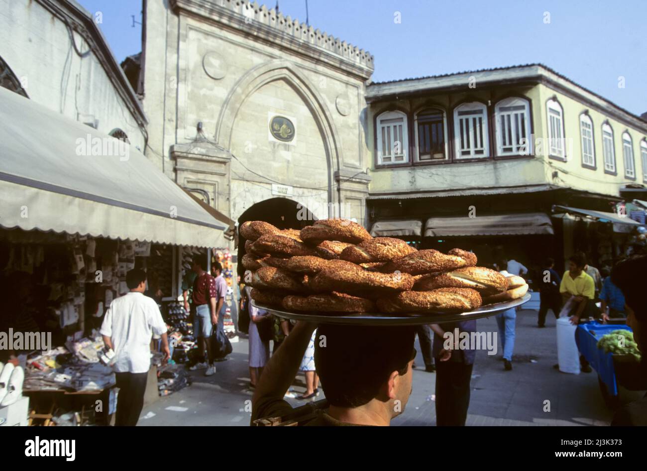 A food vendor carrying a plate of bagels on his head.; Istanbul, Turkey ...