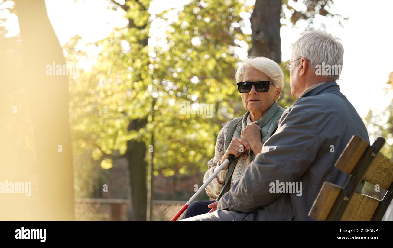 Senior Caucasian man with his disabled blind wife in the park ...
