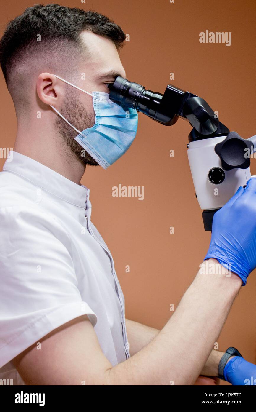 A young scientist conducting research with a microscope. Working with a ...