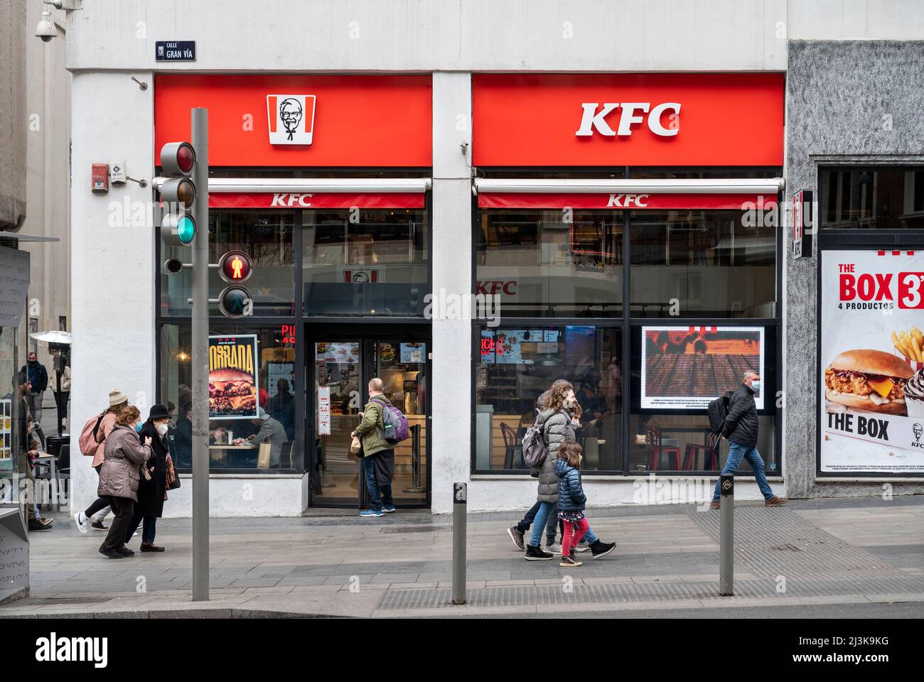 Pedestrians walk past an American fast food chicken restaurant chain ...