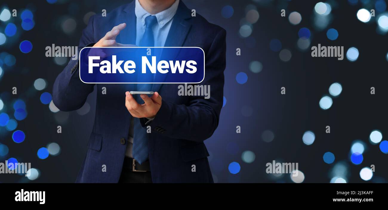 Businessman with smartphone and text FAKE NEWS on virtual screen ...