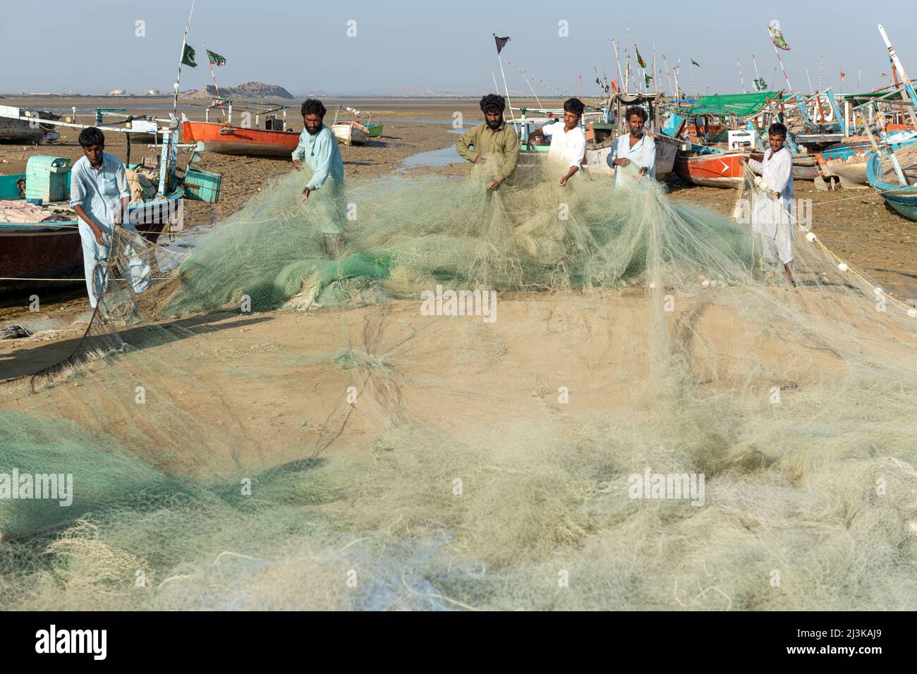 Fisherman holding fishing net near the beach. Group of fisherman ...