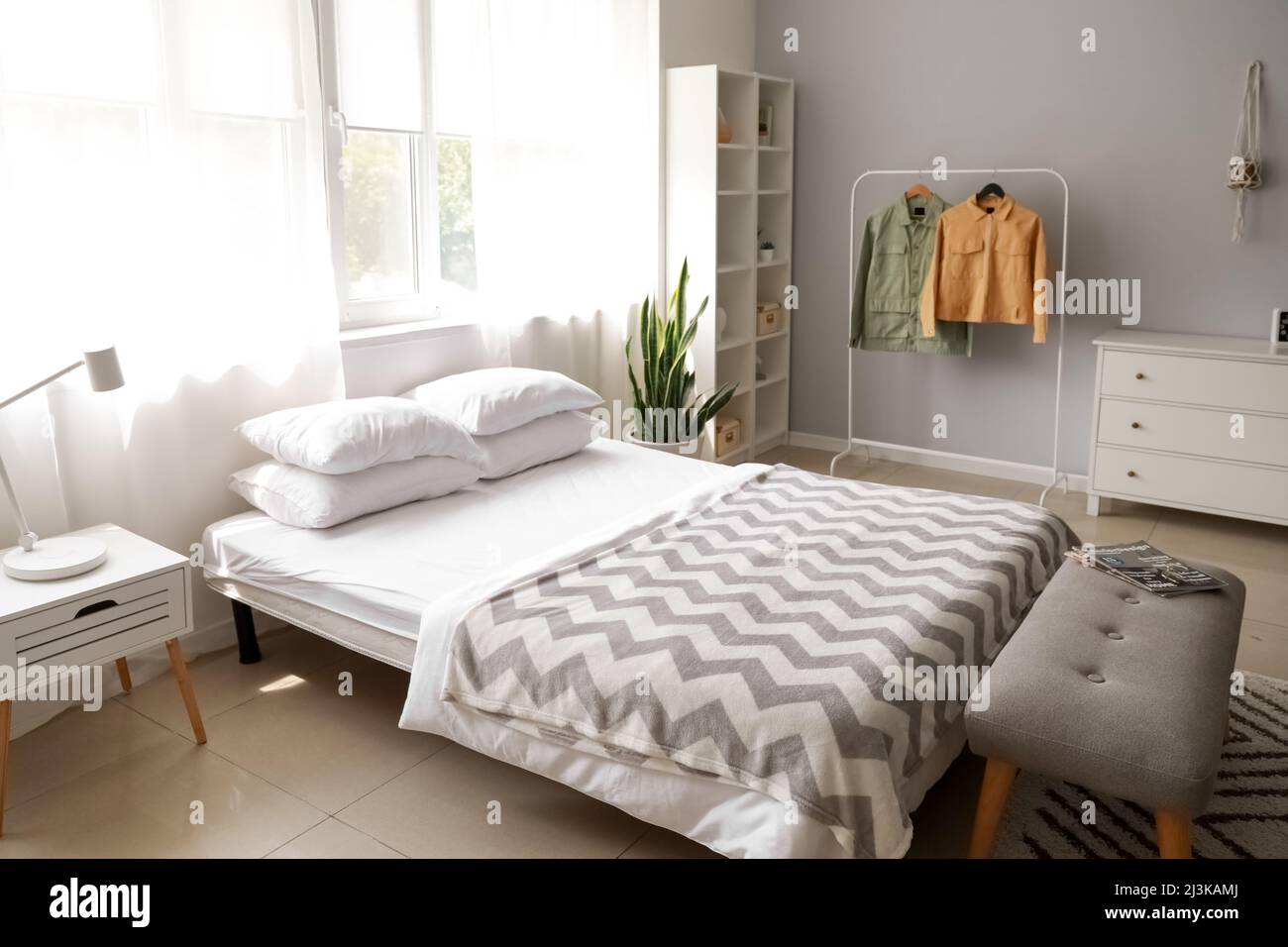 Interior of modern bedroom with rack and jackets Stock Photo - Alamy