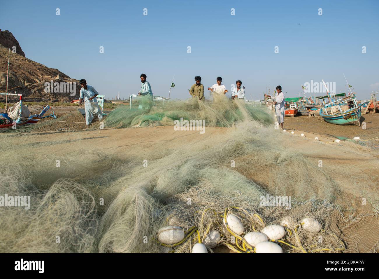 Fisherman holding fishing net near the beach. Group of fisherman ...