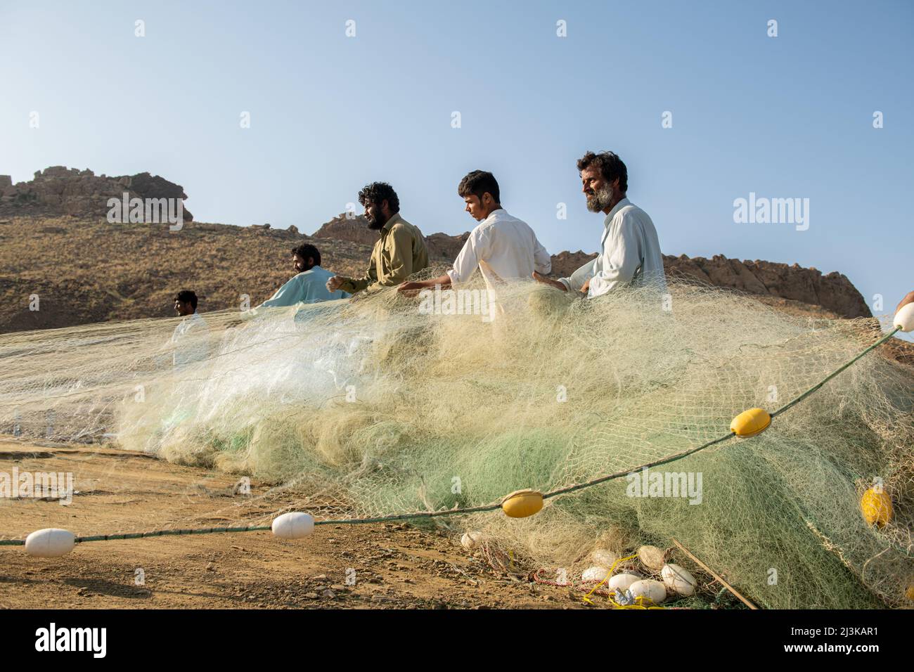 Fisherman holding fishing net near the beach. Group of fisherman ...