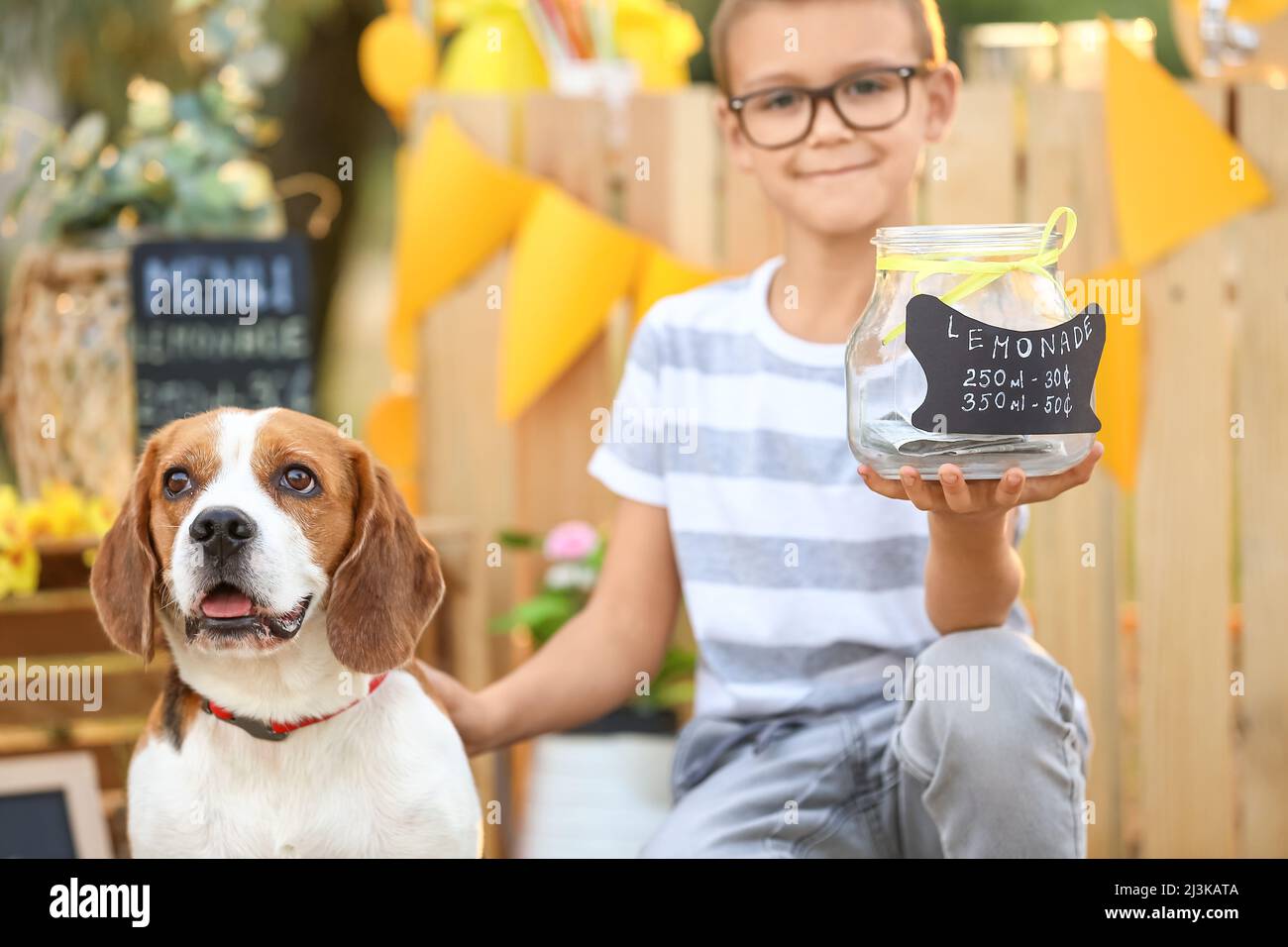 Cute boy with dog selling lemonade in park Stock Photo - Alamy