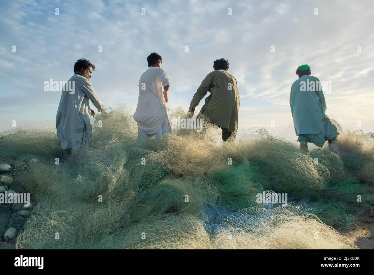 Fisherman holding fishing net near the beach. Group of fisherman ...