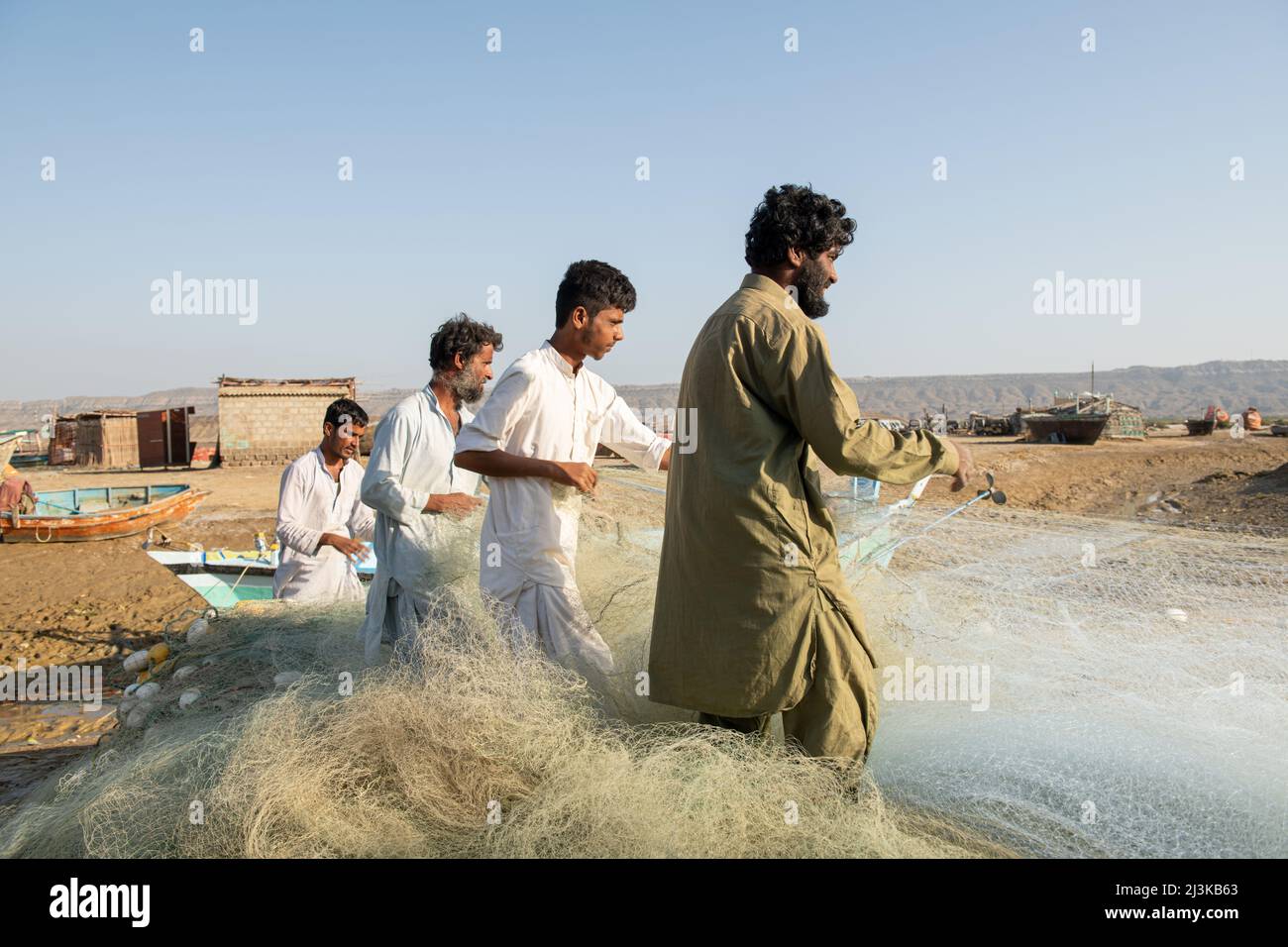 Fisherman holding fishing net near the beach. Group of fisherman ...