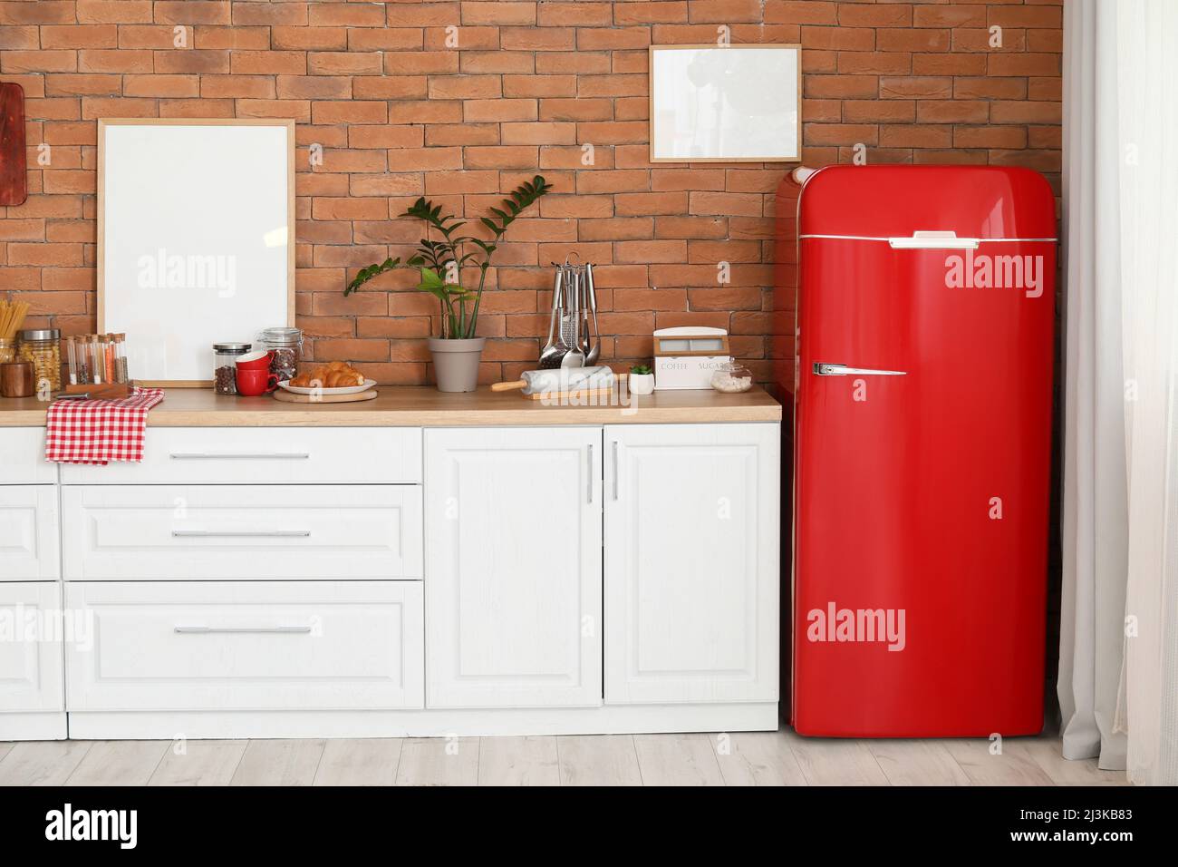 Stylish refrigerator and counter near brick wall in kitchen Stock Photo ...