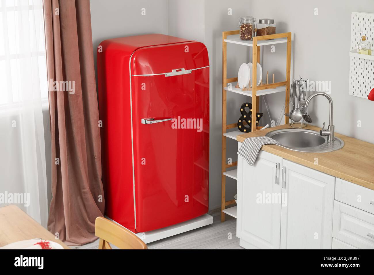 Interior of light kitchen with red fridge and shelving unit Stock Photo ...