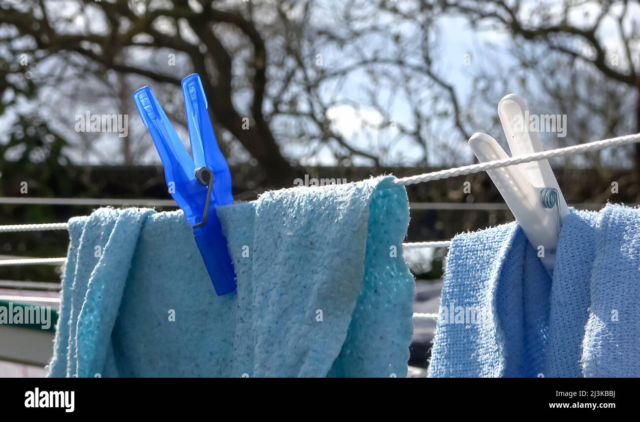 Clothes hung out to dry on a washing line and fastened by the clothes ...