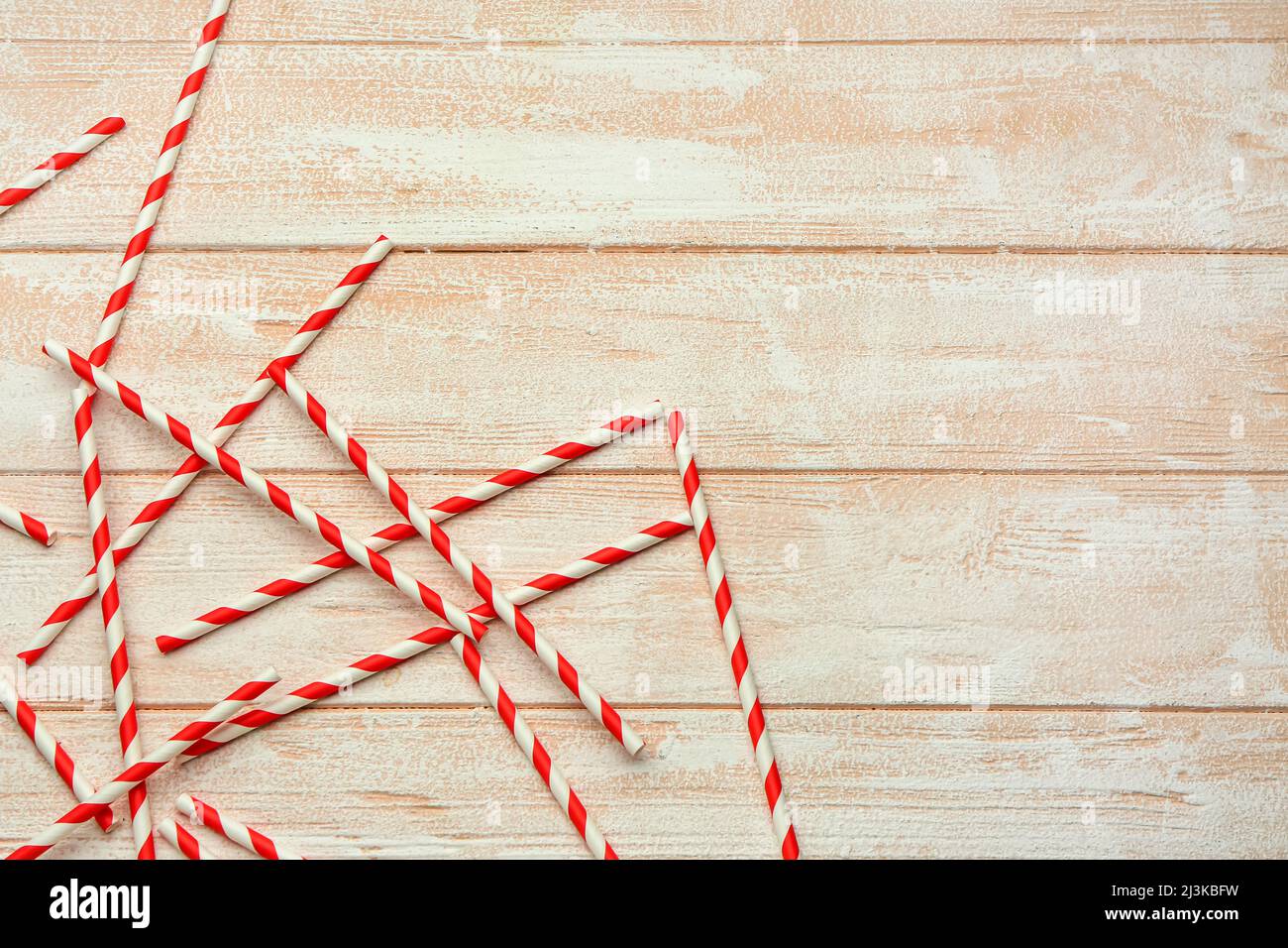 Stylish straws for drinks on light wooden background Stock Photo - Alamy