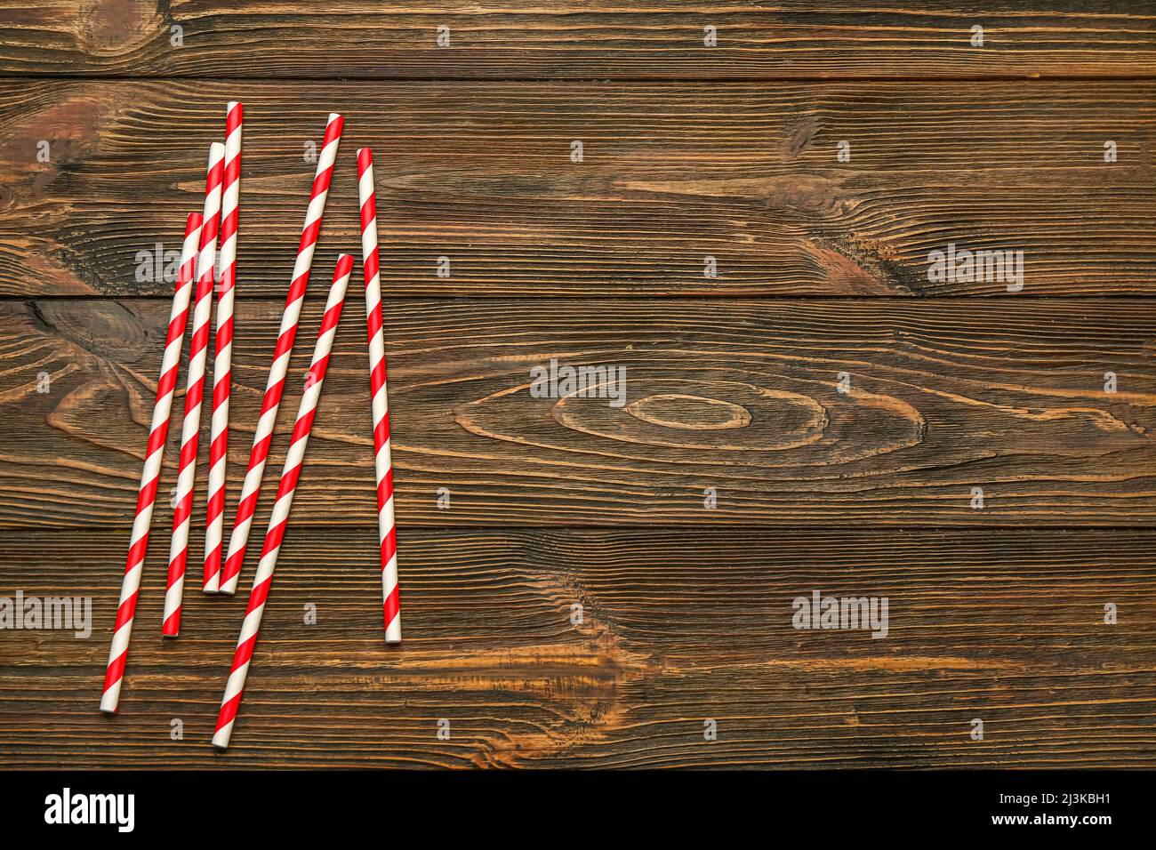 Stylish straws for drinks on wooden background Stock Photo - Alamy