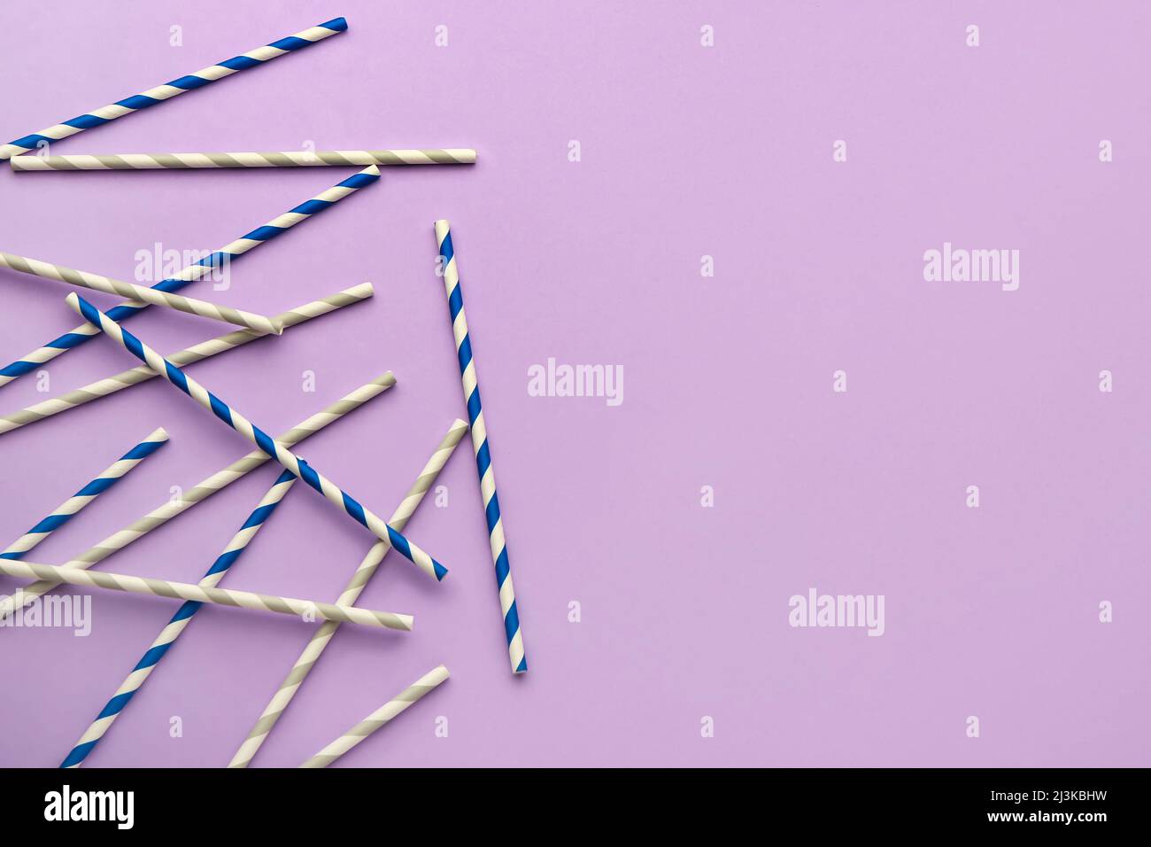 Stylish straws for drinks on purple background Stock Photo - Alamy