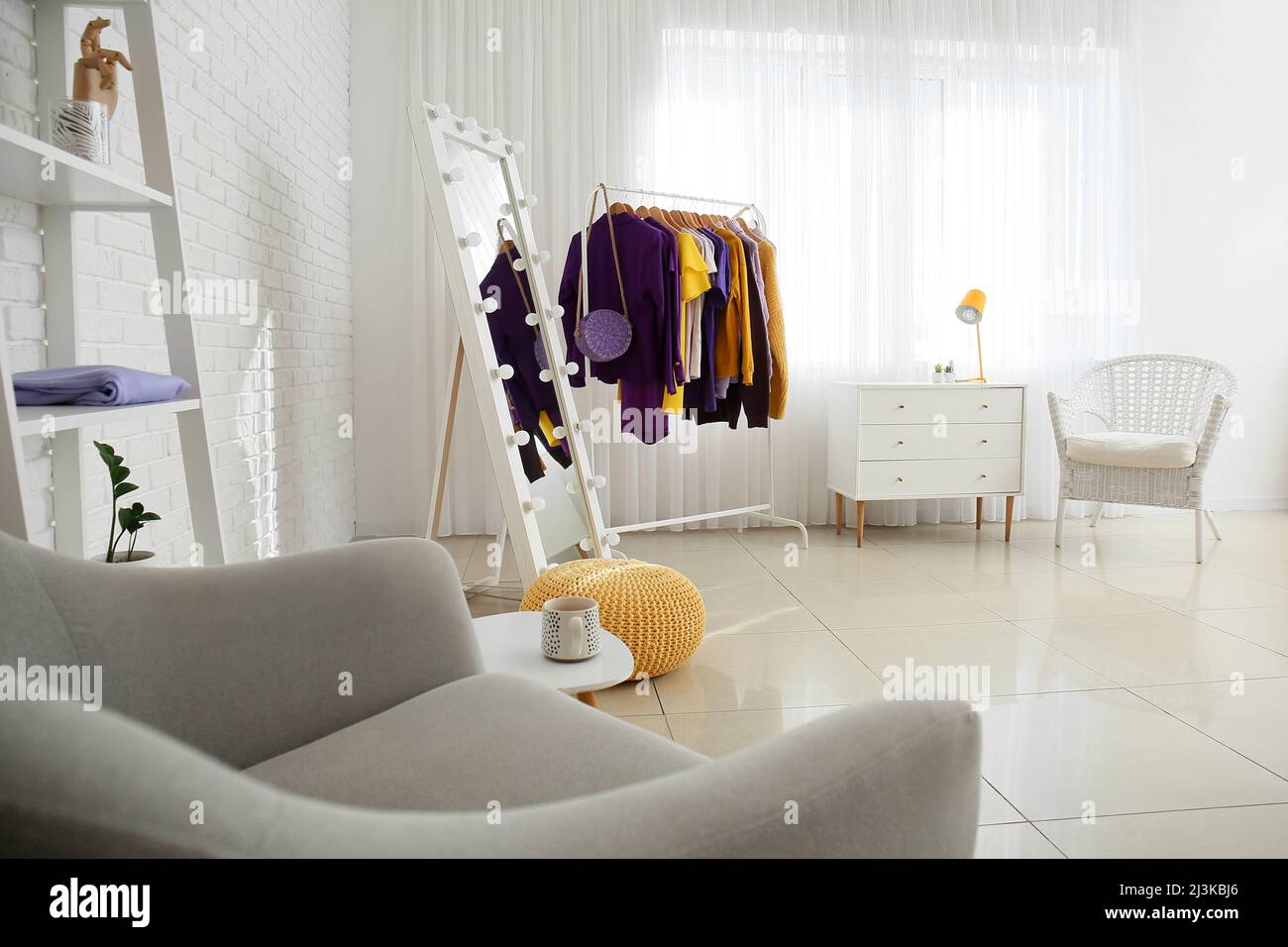 Interior of light dressing room with clothes, mirror and commode Stock ...