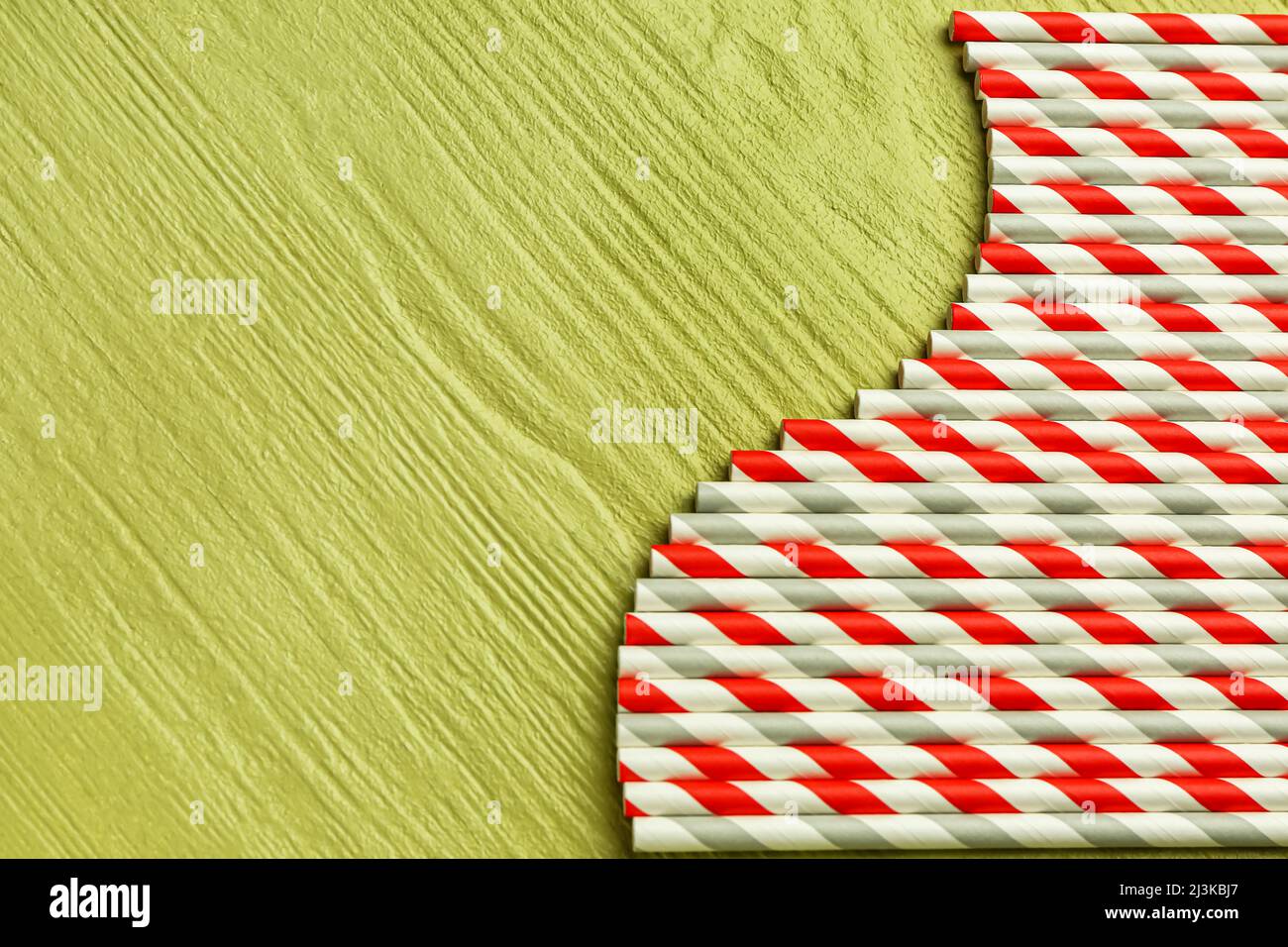Stylish straws for drinks on green wooden background Stock Photo - Alamy
