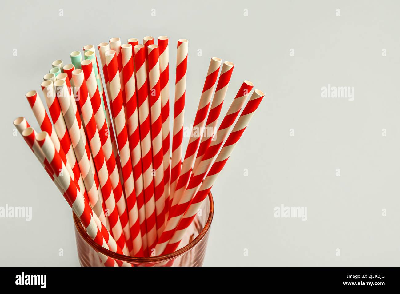 Glass with stylish straws for drinks on light background Stock Photo ...