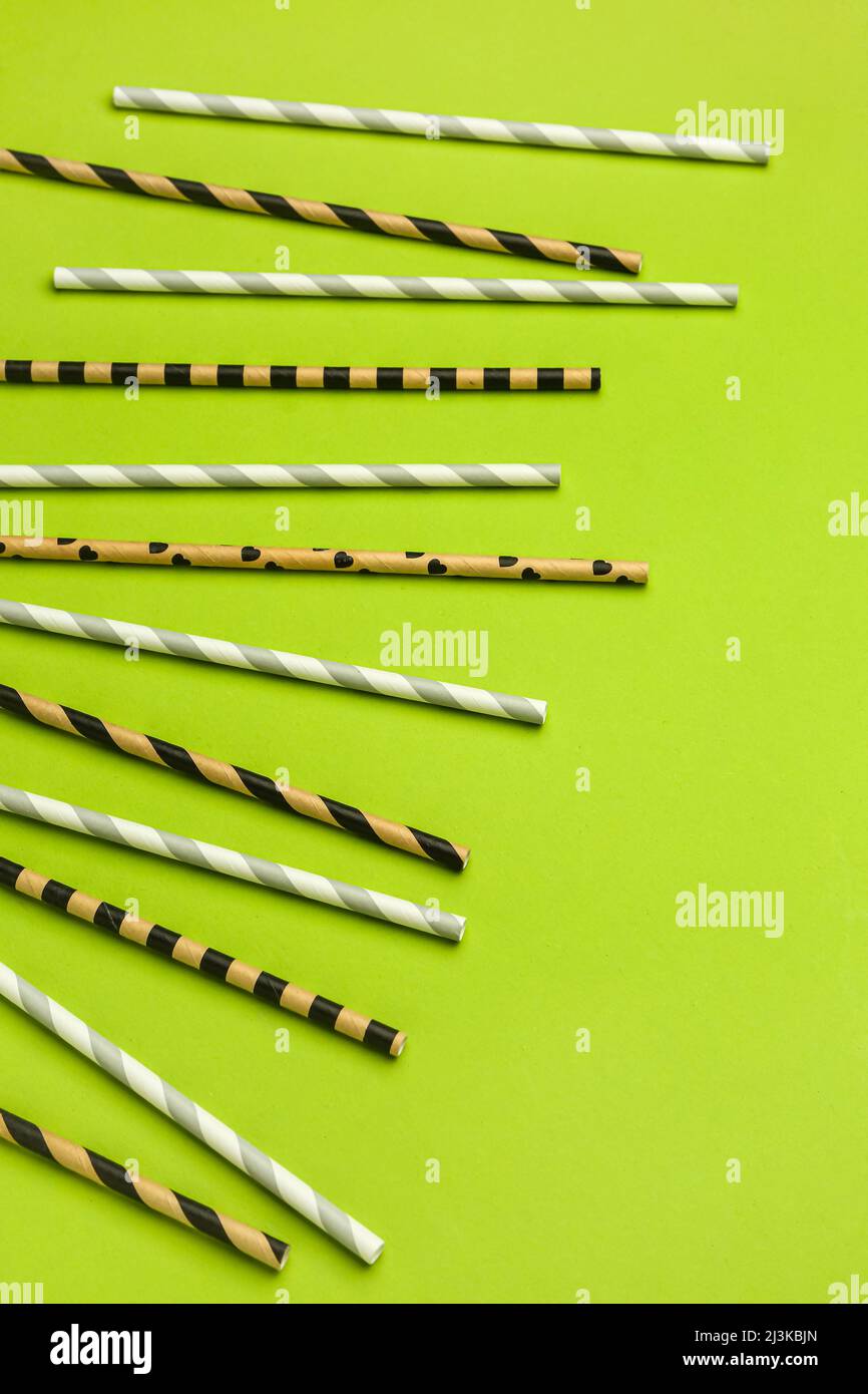Stylish straws for drinks on green background Stock Photo - Alamy