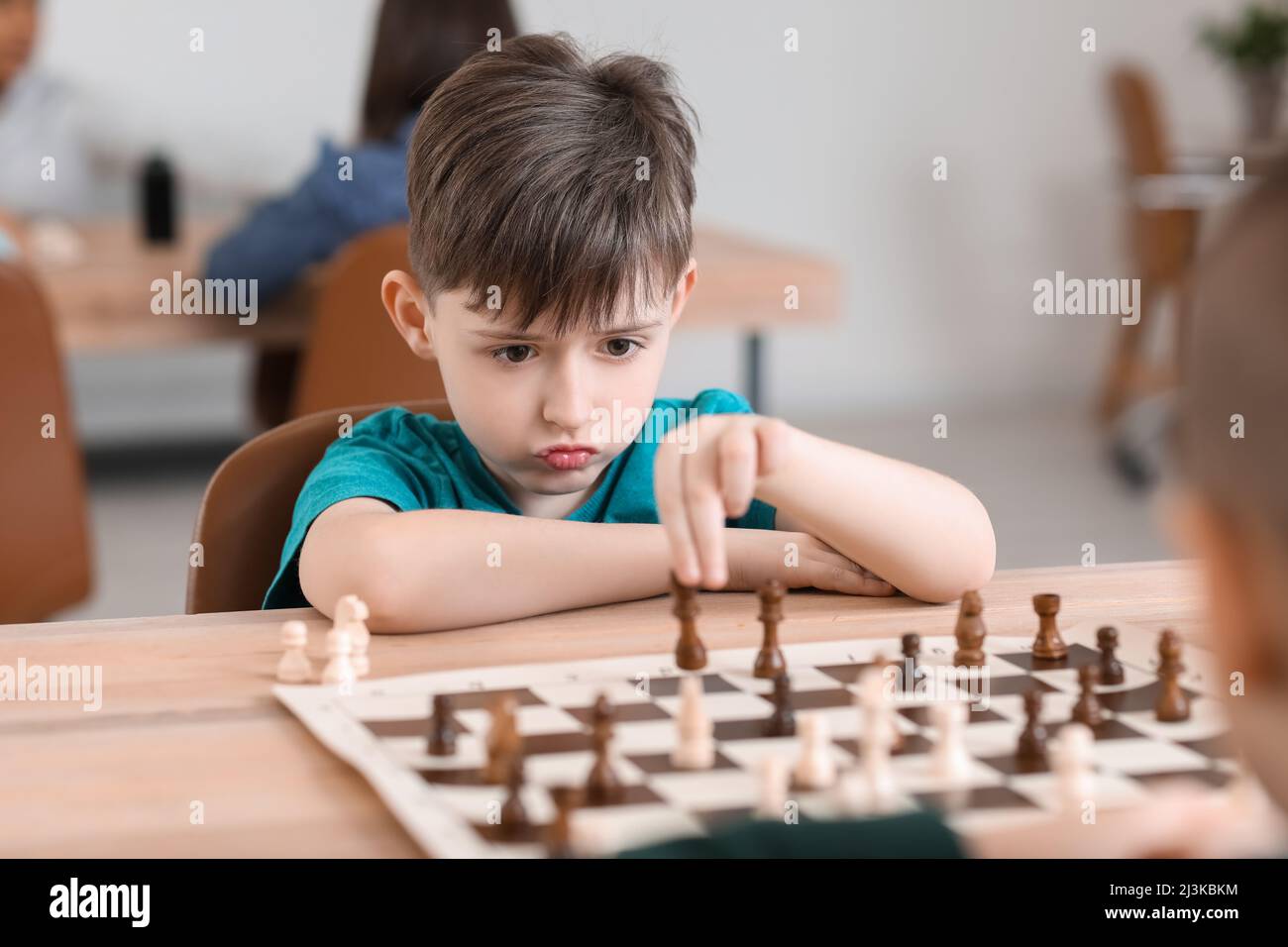 Little boy playing chess during tournament in club Stock Photo - Alamy