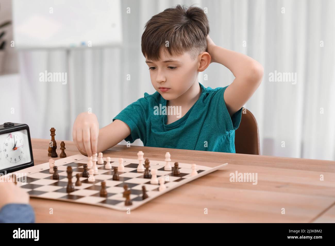 Little boy playing chess during tournament in club Stock Photo - Alamy