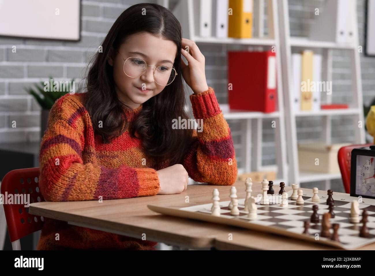 Little girl playing chess during tournament in club Stock Photo - Alamy
