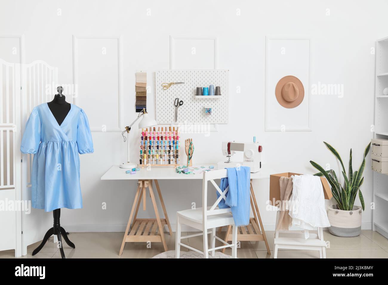Interior of stylish atelier with tailor's workplace, mannequin and ...