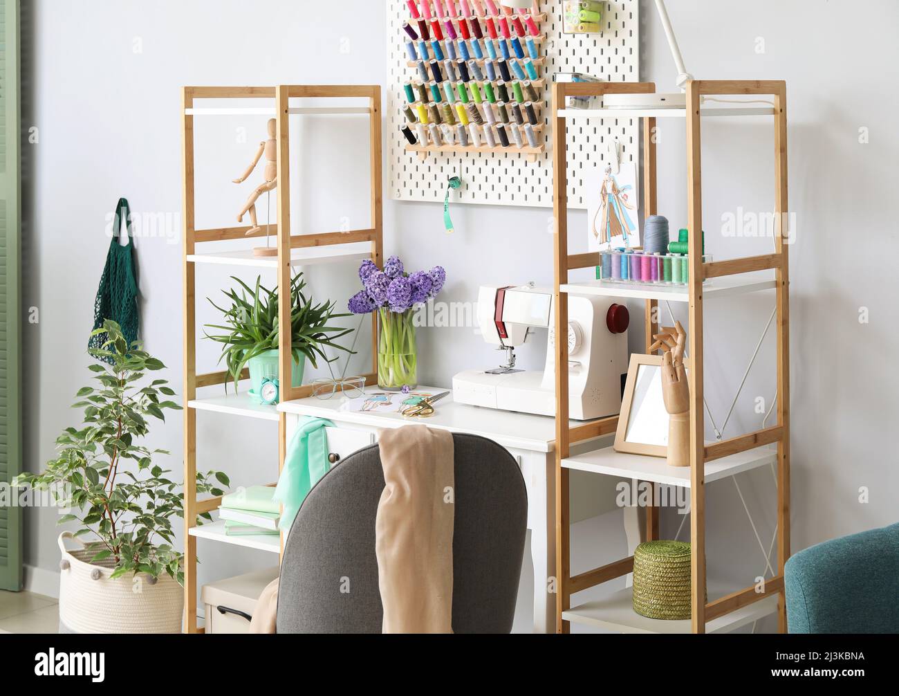 Interior of stylish atelier with tailor's workplace, shelving units and ...