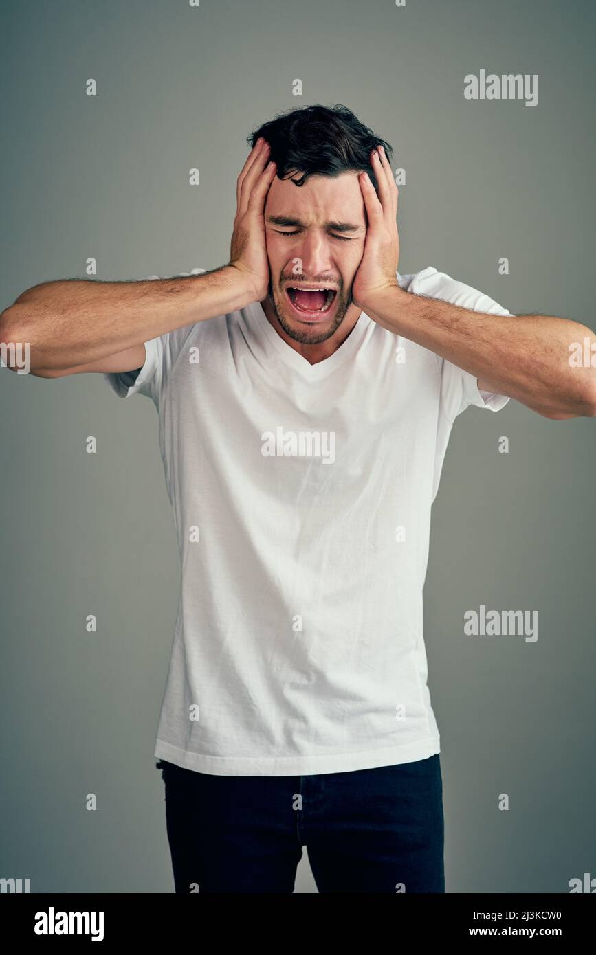 Sometimes you just need to scream. Studio shot of a casual young man ...