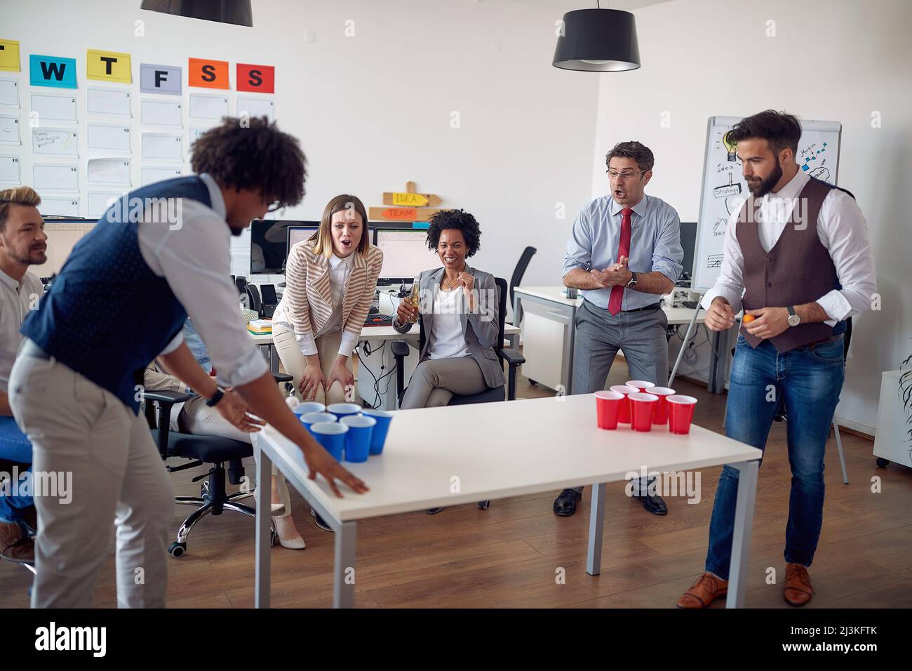 A group of cheerful employees playing during a break in a relaxed ...