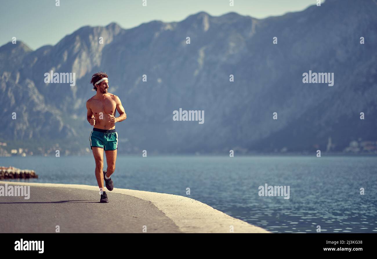 Young Man running and exercises outdoors near beautiful lake Stock ...