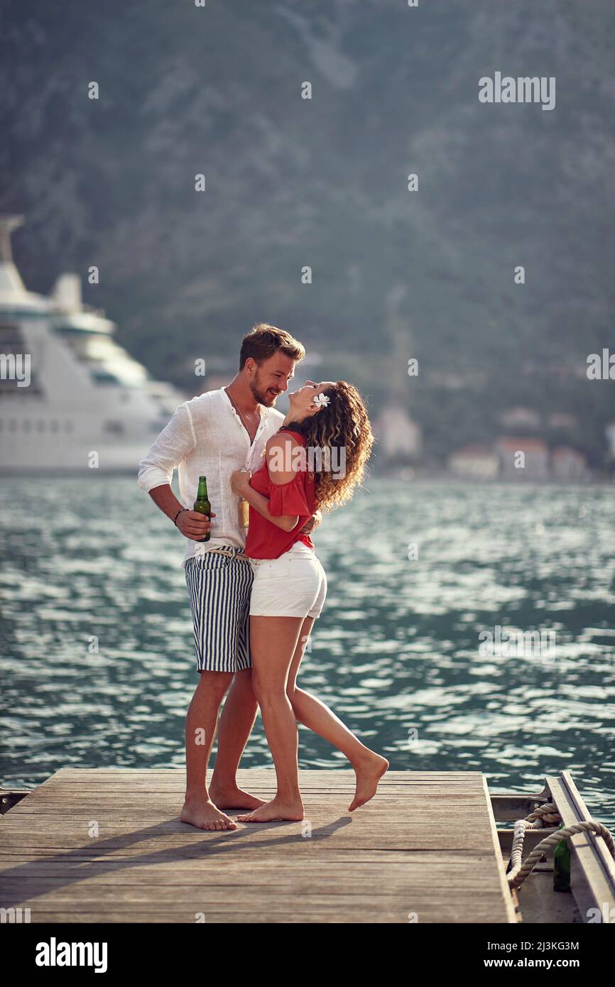 Couple flirt on lake dock.Young Man and woman having summer fun Stock ...