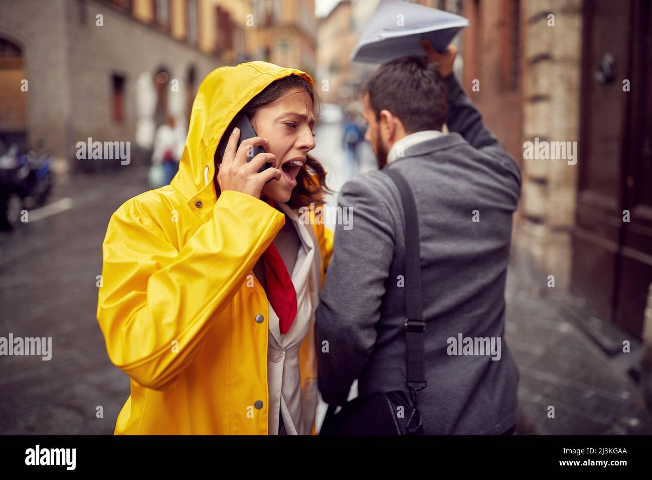 A young woman who is walking the city in a hurry manner and speaking on ...
