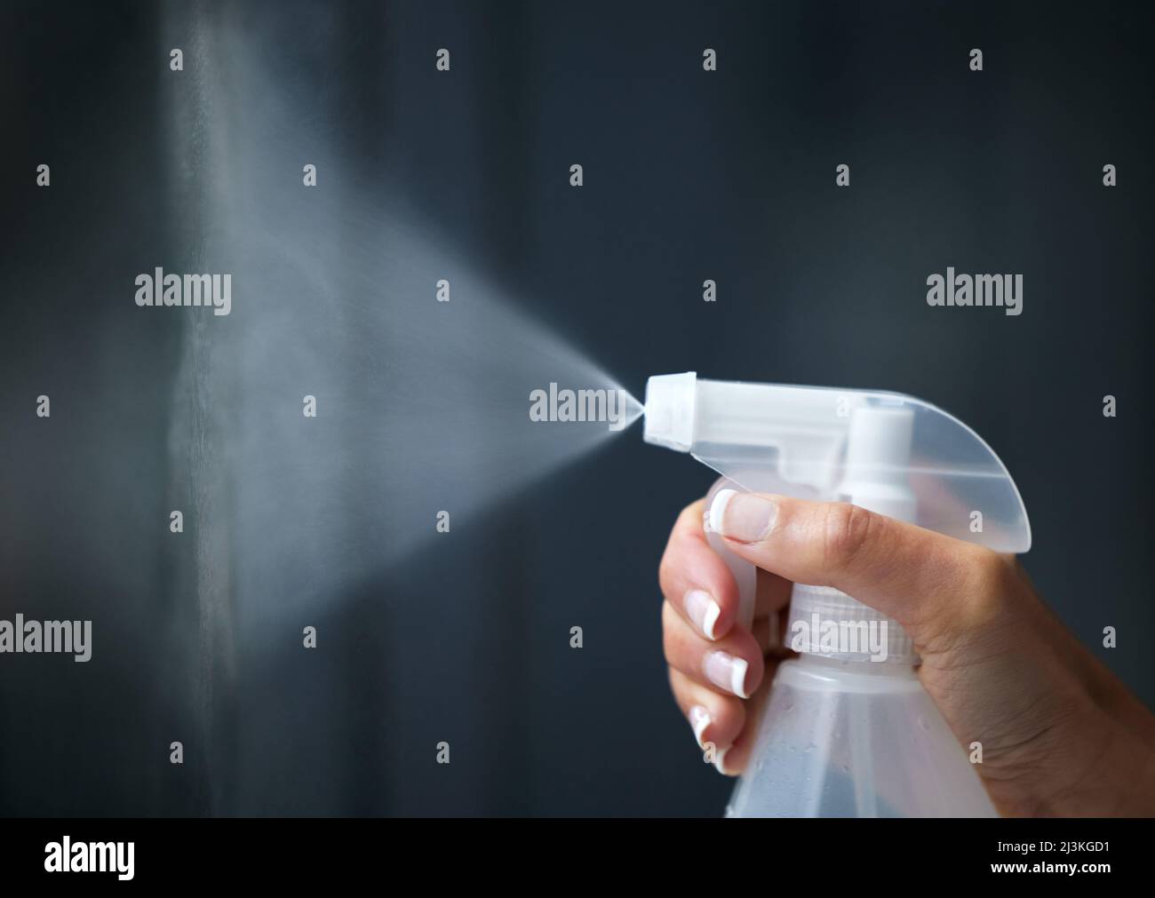 This is the best window cleaner. Shot of a woman spraying bottle of ...