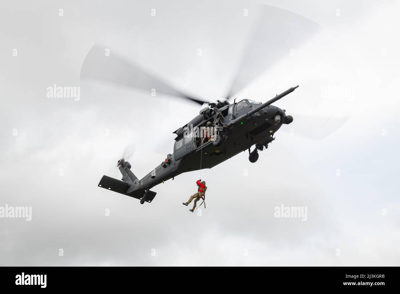 A 31st Rescue Squadron pararescueman hangs out the side of a 33rd RQS HH-60G Pave Hawk as they ...