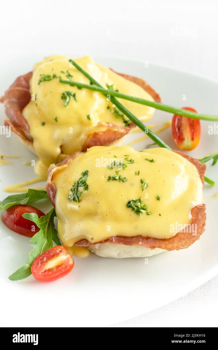 eggs benedict breakfast with ham and hollandaise sauce on white ...