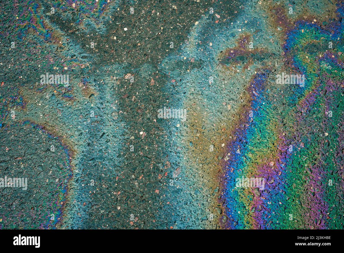 Rainbow gasoline oil spill on the pavement as a texture or background ...