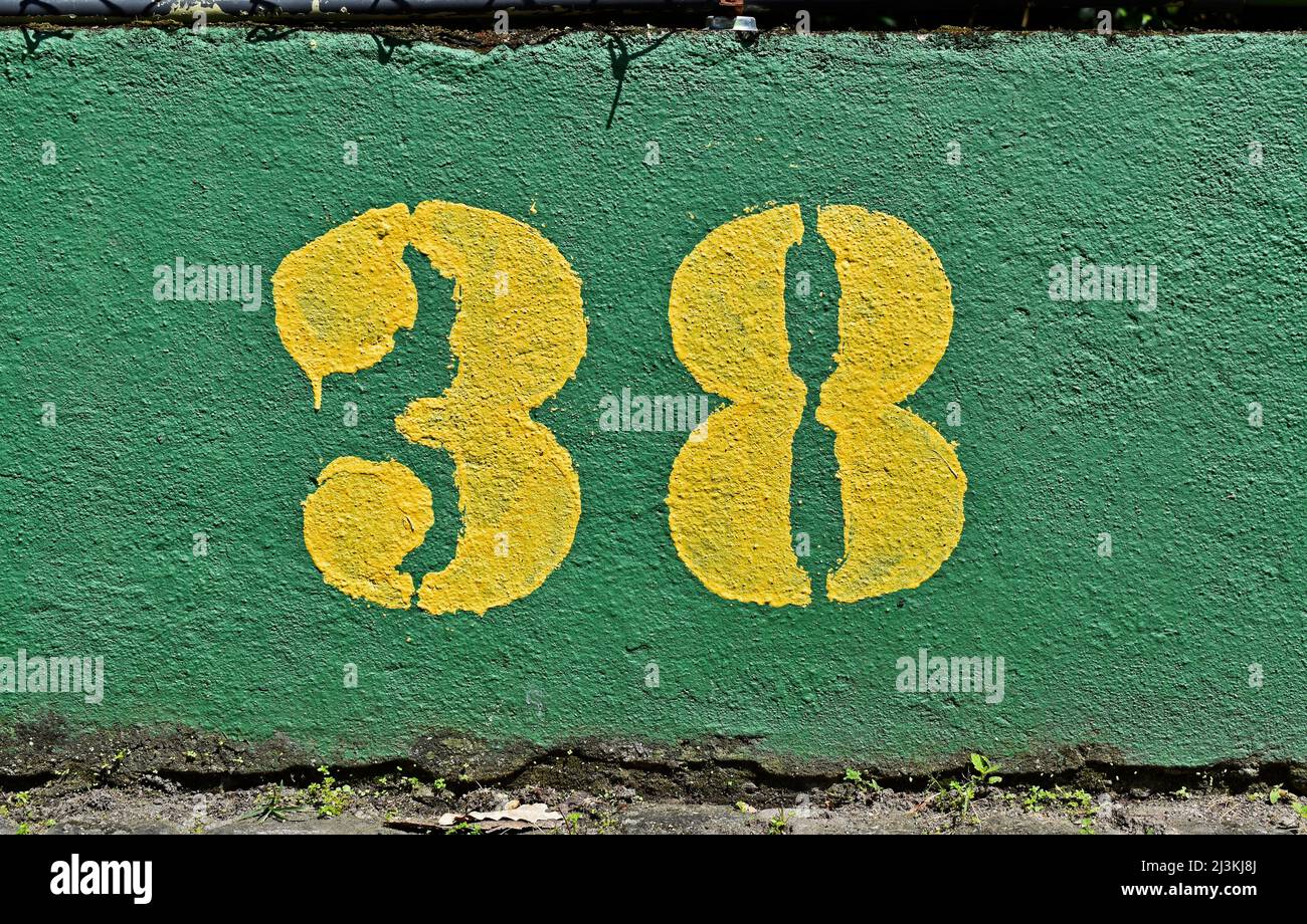 Number 38 painted in yellow on a green wall Stock Photo - Alamy