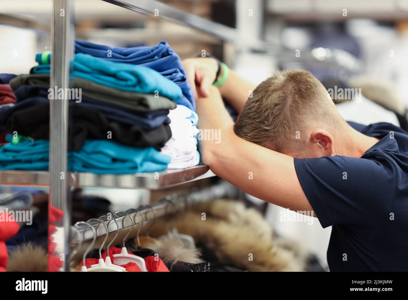 Tired seller or buyer in clothing store Stock Photo - Alamy