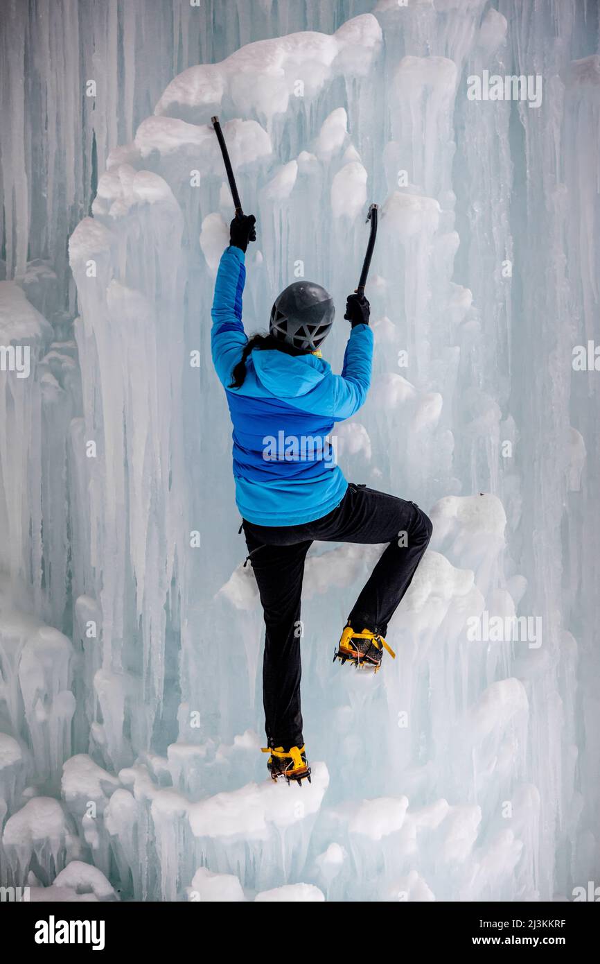 A woman climbs an ice wall using ice axes and crampons Stock Photo - Alamy