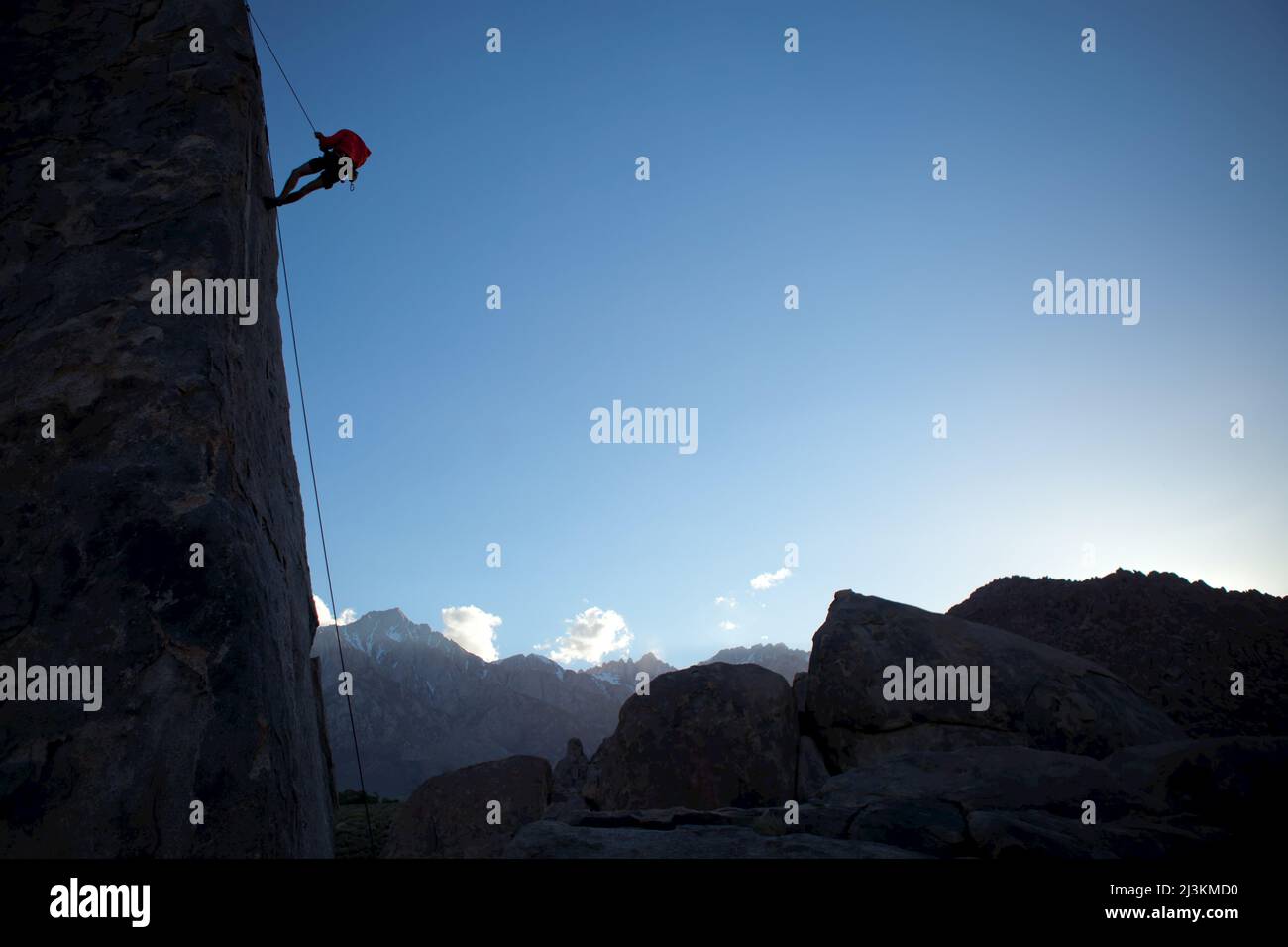 A climber on the 'Sharks Fin' formation; Mt. Whitney in the background ...