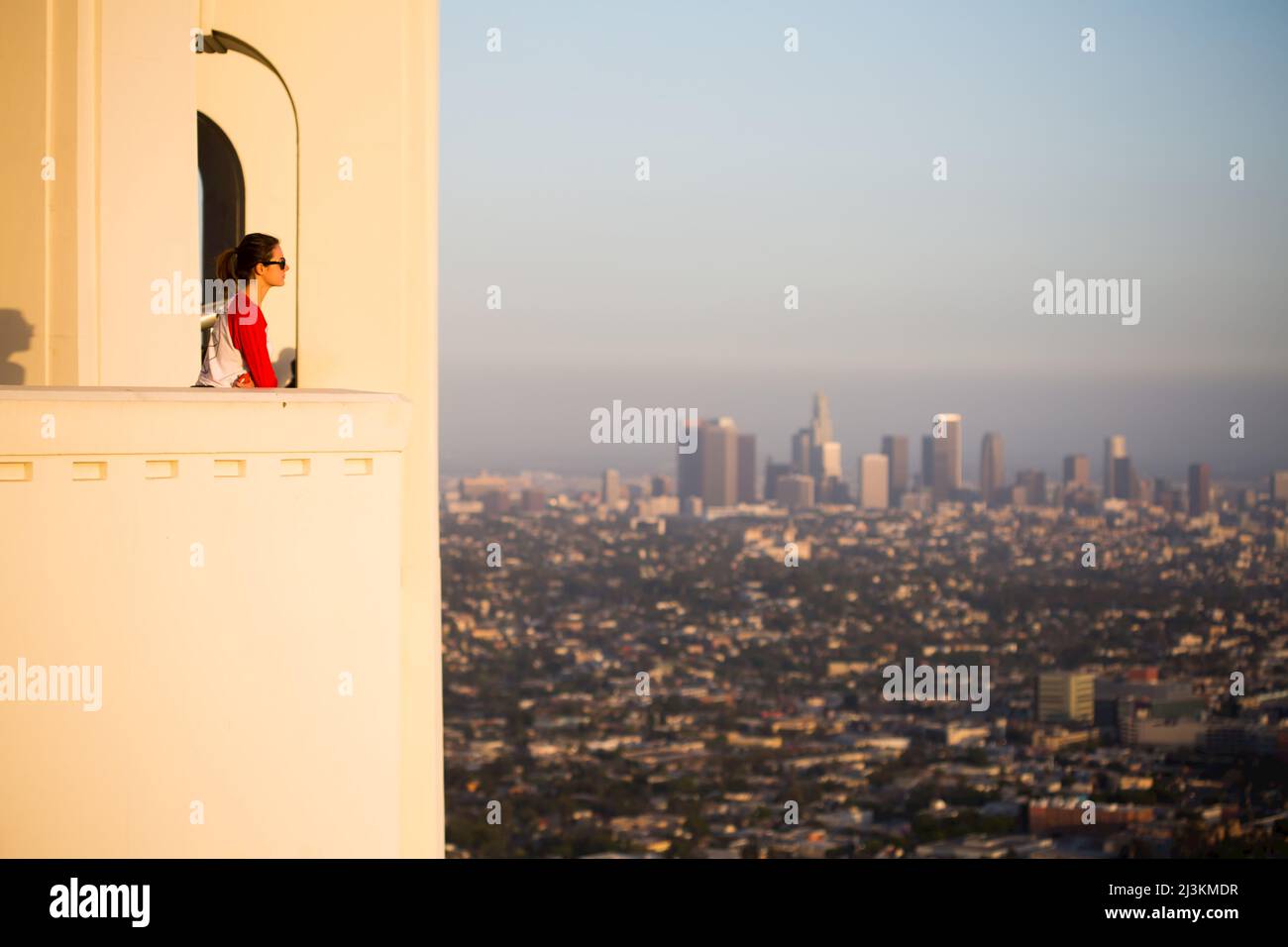A young woman looks out from Griffith Observatory at the Los Angeles ...