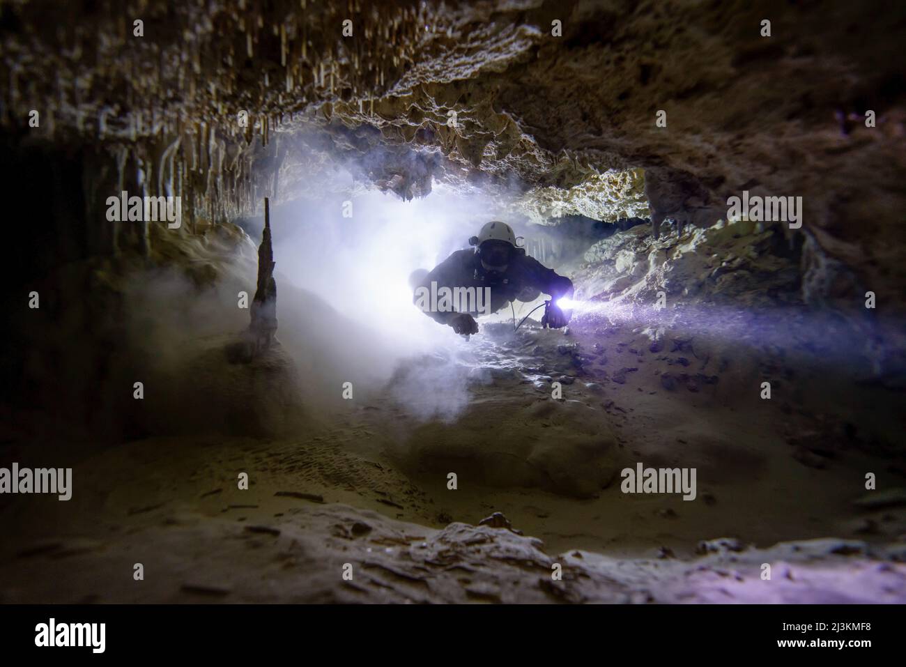 A cave diver passes through a silted out passage Stock Photo - Alamy
