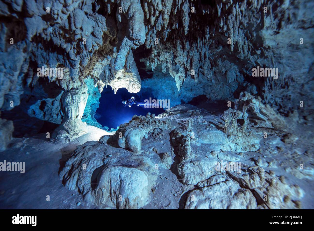 A cave diver passes through a beautiful white section of limestone deep ...