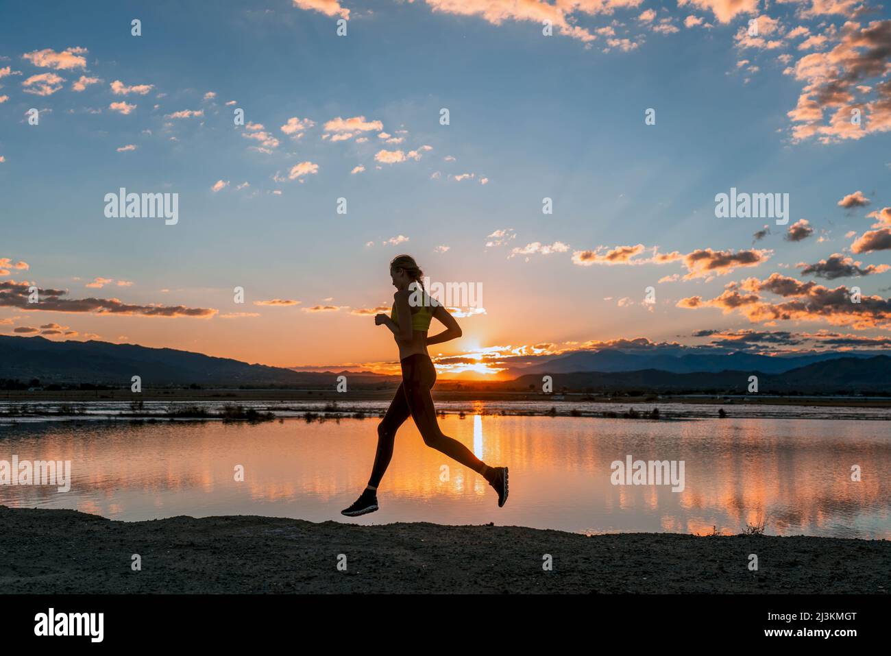 Young woman running along lake hi-res stock photography and images - Alamy