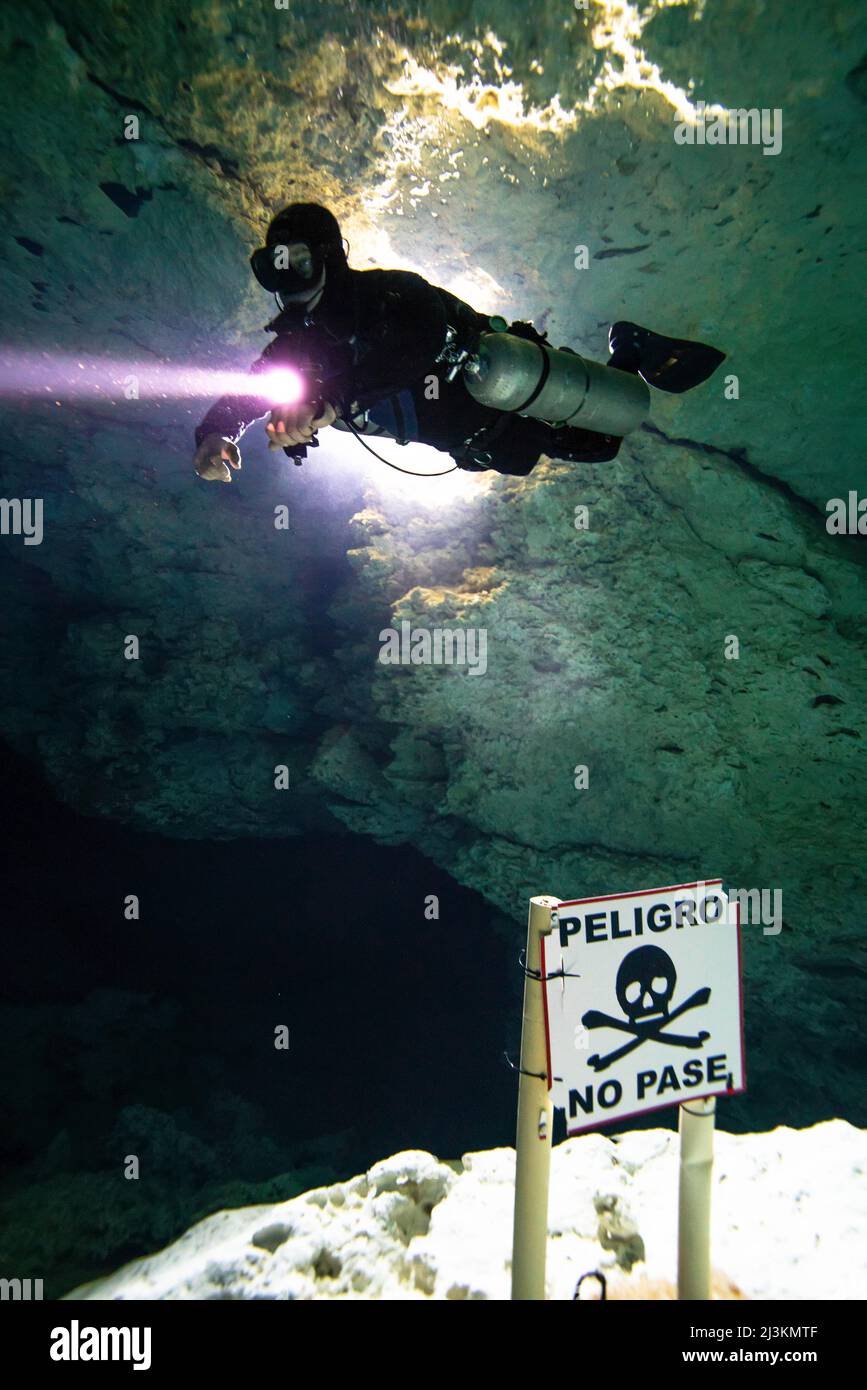 A cave diver passes a warning to keep untrained divers from entering ...
